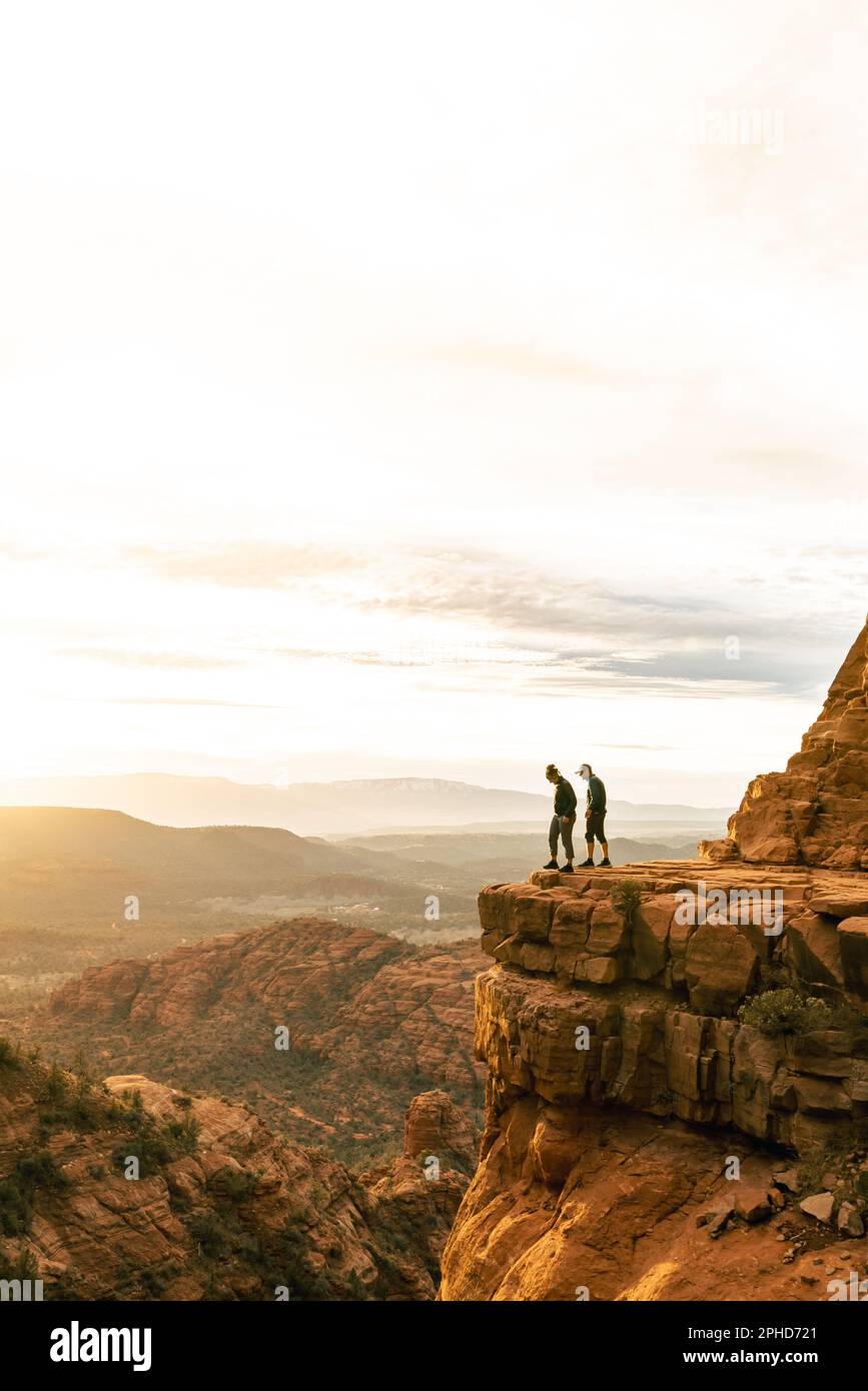 Two people married couple stand in amazement at epic viewpoint on top ...