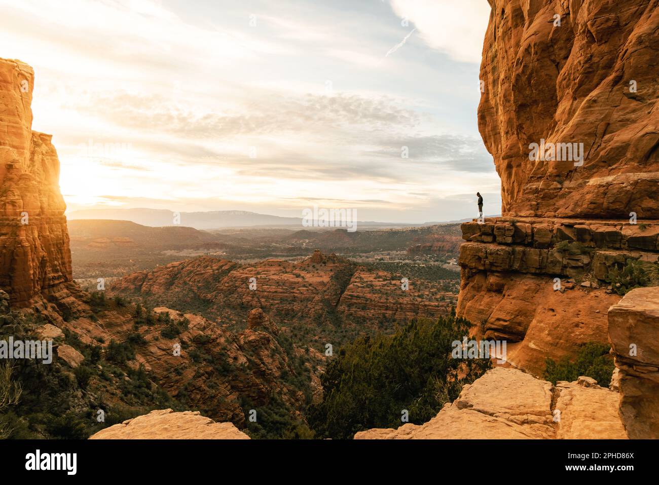 Woman looking down at cliff during dramatic sunset from Cathedral Rock ...