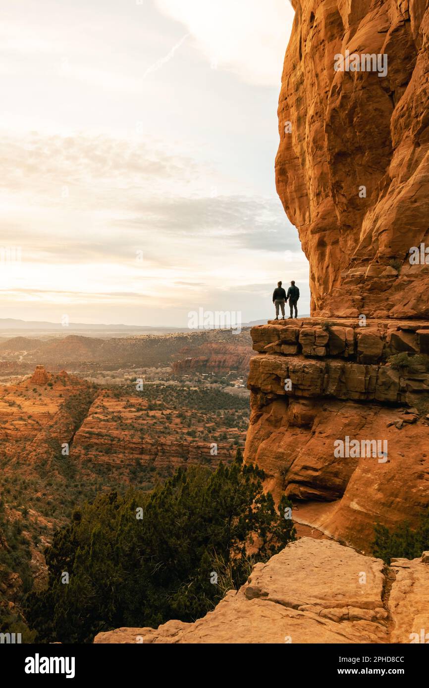 Young heterosexual couple holds hands at viewpoint during dramatic ...