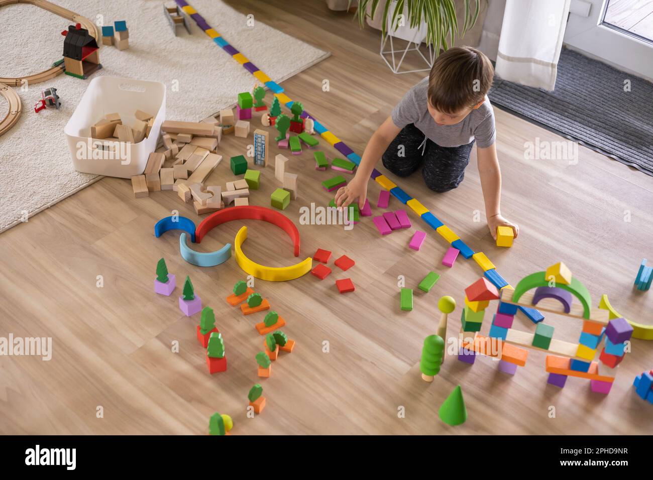 Confident male kid building fortress tower architecture wooden bricks ...