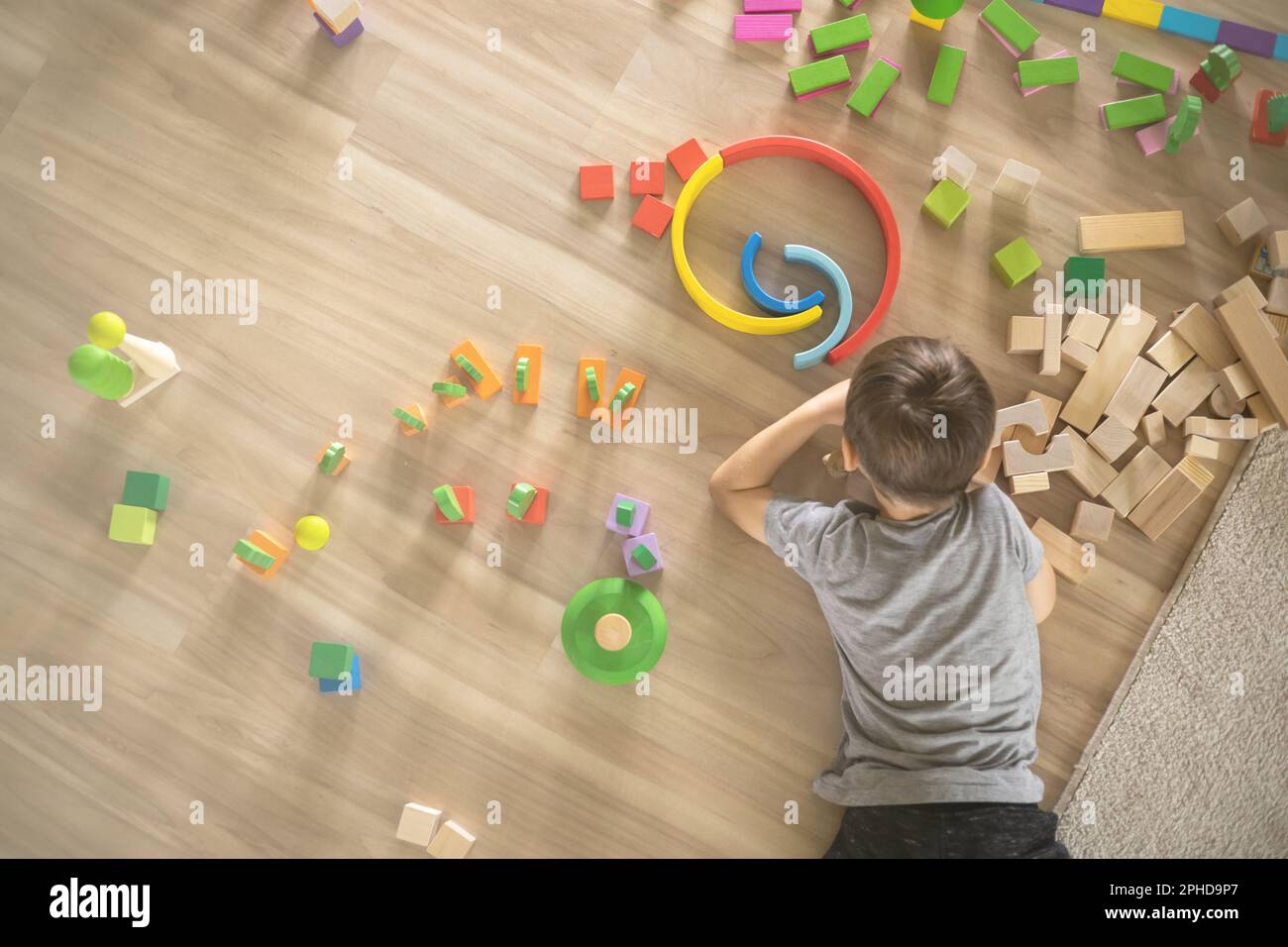 Confident male kid building fortress tower architecture wooden bricks ...