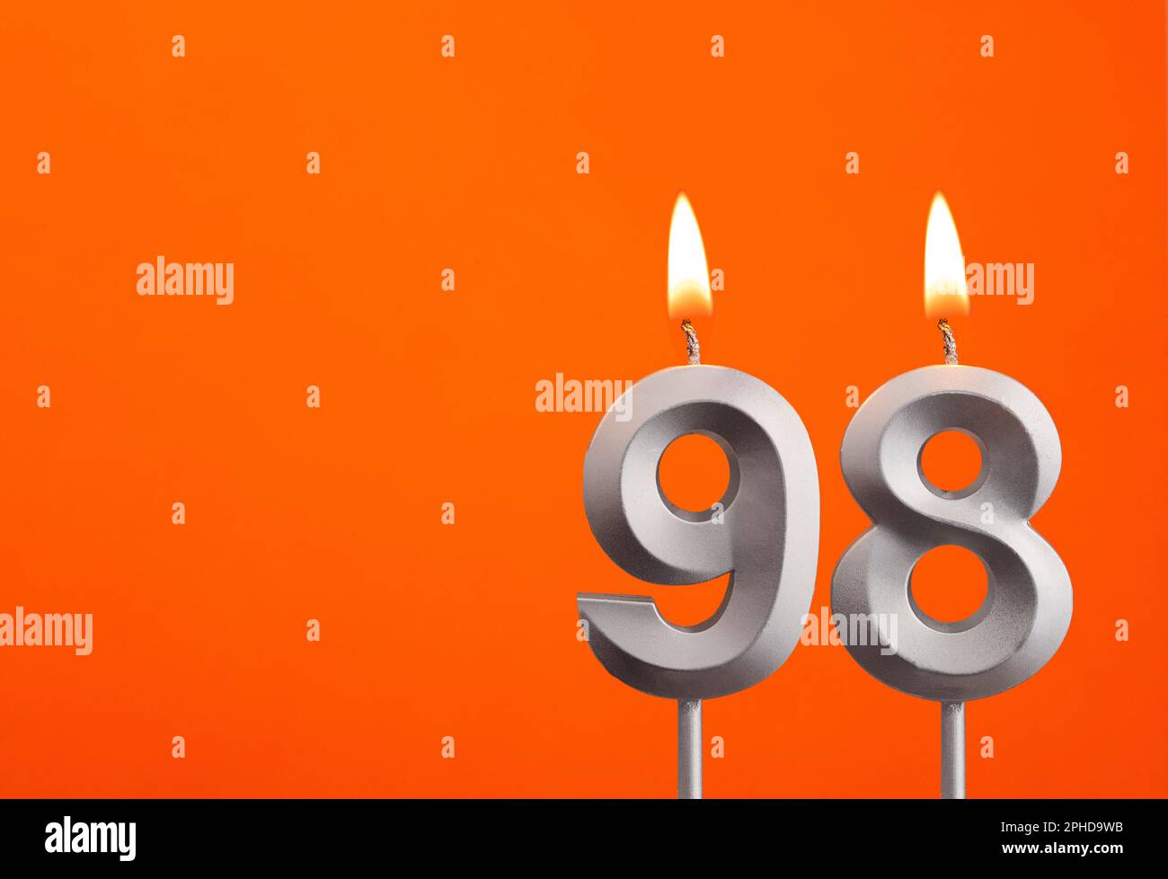 Candle number 98 - Birthday in orange background Stock Photo - Alamy