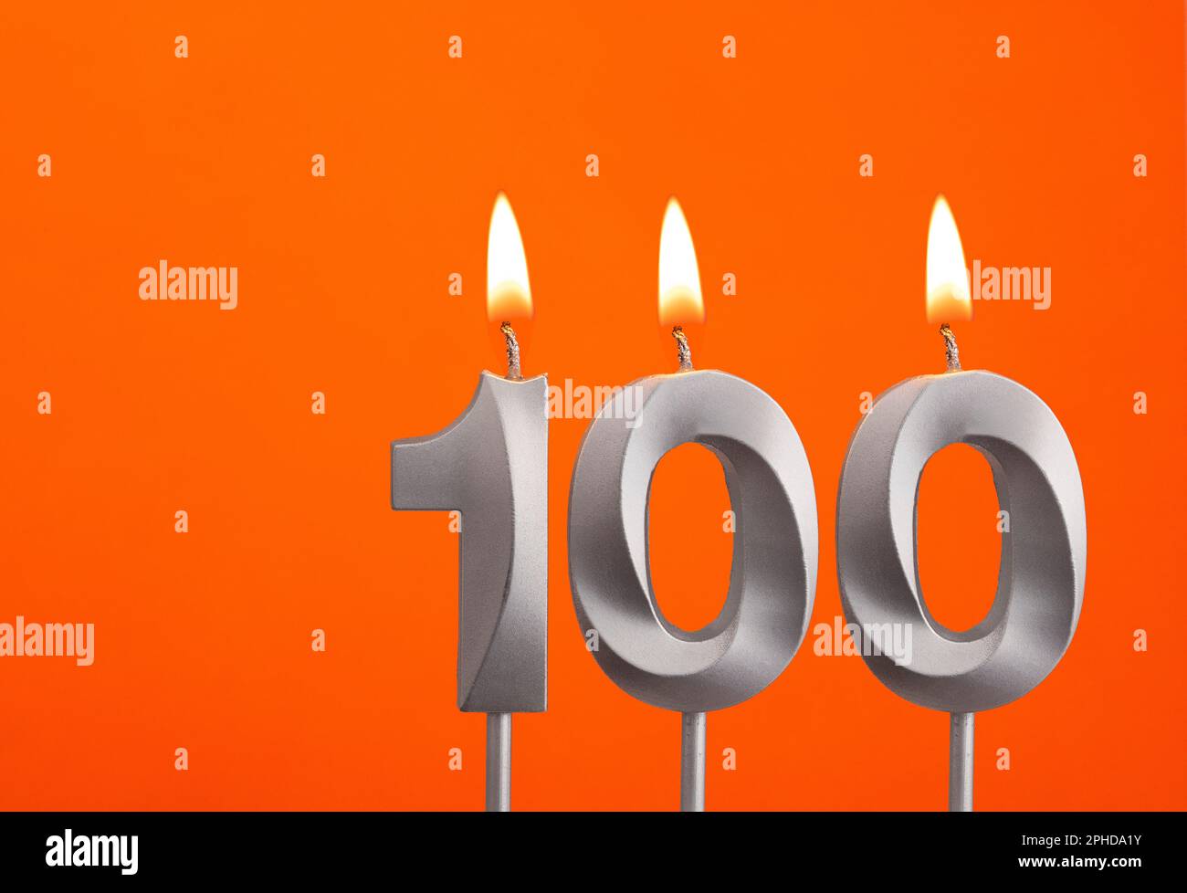 Candle number 100 - Birthday in orange background Stock Photo - Alamy