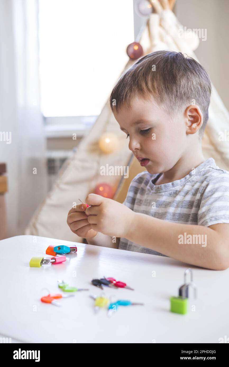 The child works with Montessori material with colored locks. Picks up ...