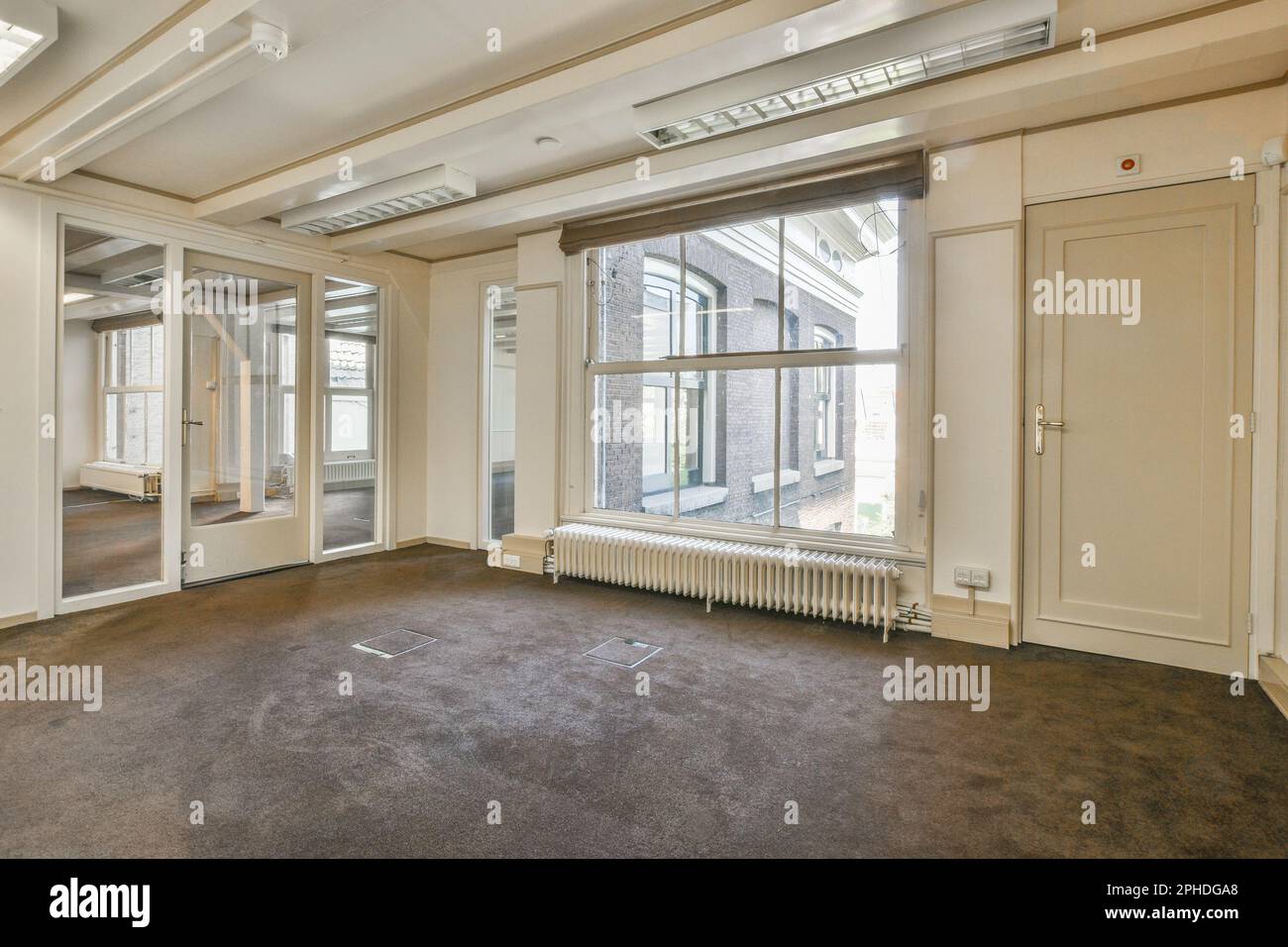 an empty room with large windows and no one person standing in the room ...