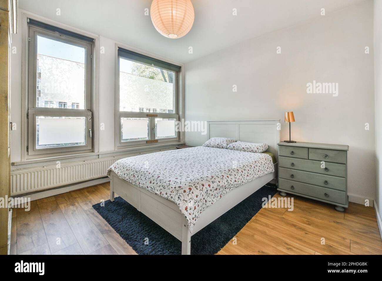 a bedroom with a bed, dressers and window in the back wall to the other ...