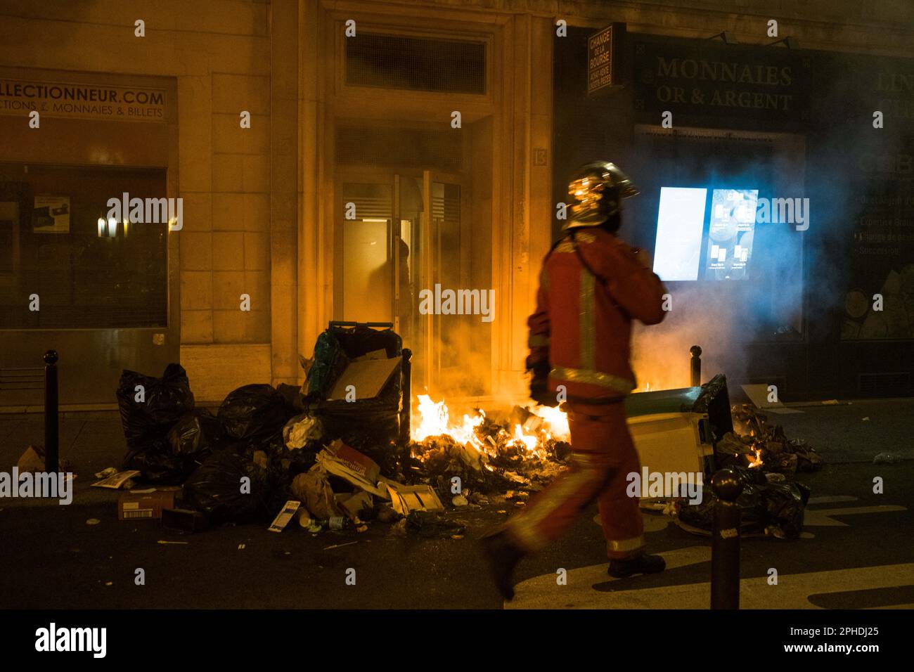 Paris, France. 23rd Mar, 2023. A firefighter walks next to bags of ...