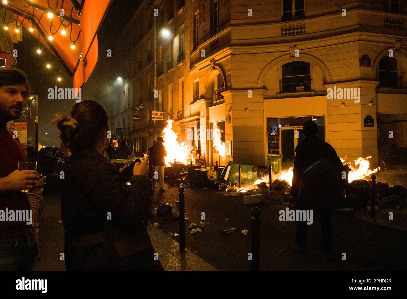 Paris, France. 23rd Mar, 2023. A man drinking a beer, looks at bags of ...