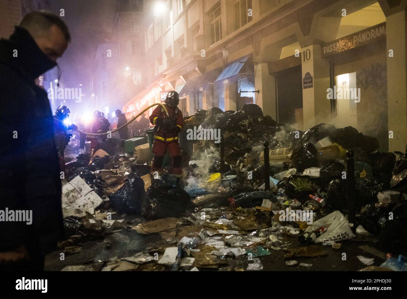 Paris, France. 23rd Mar, 2023. A firefighter tries to extinguish bags ...