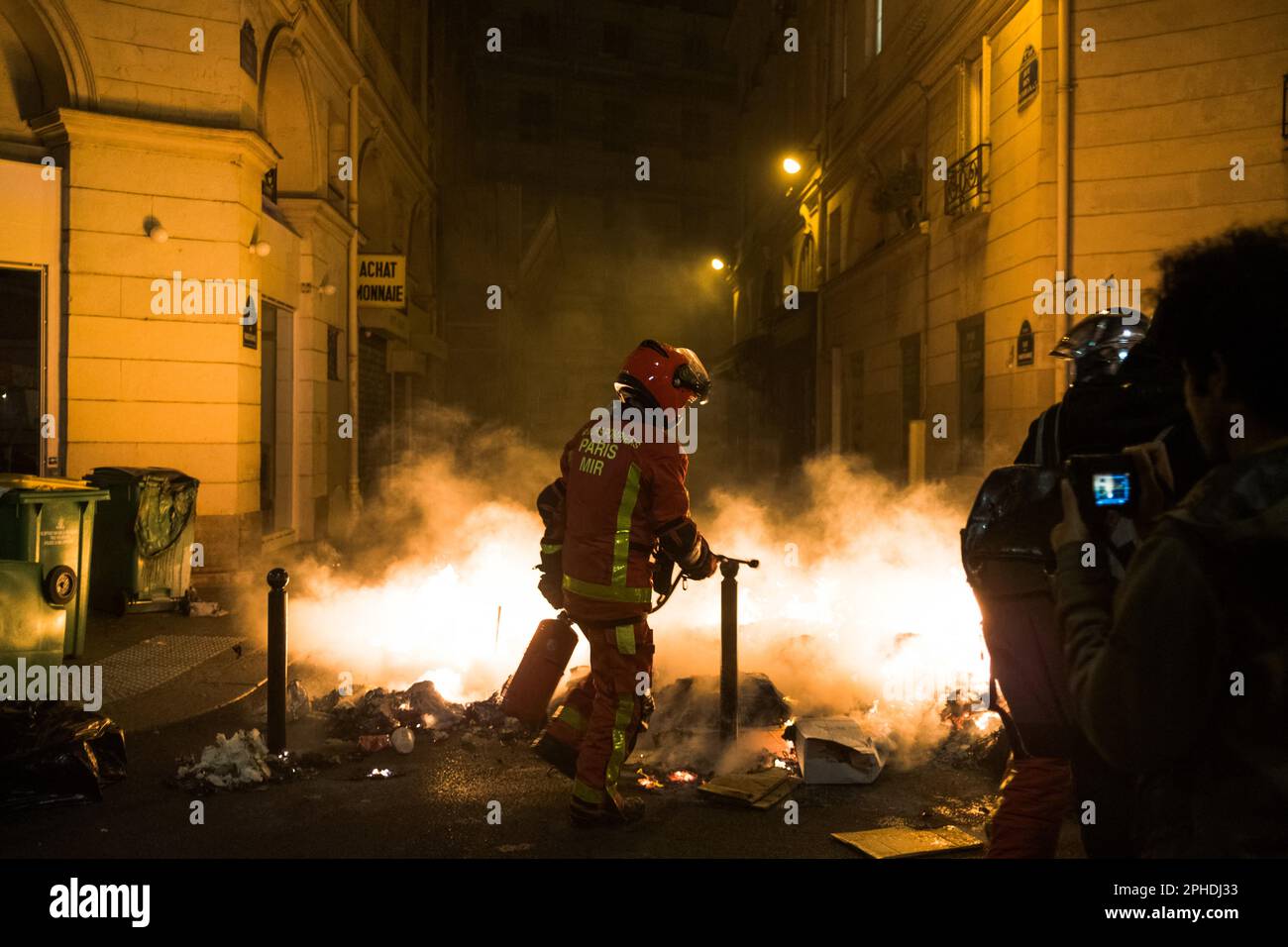 Paris, France. 23rd Mar, 2023. A firefighter tries to extinguish bags ...