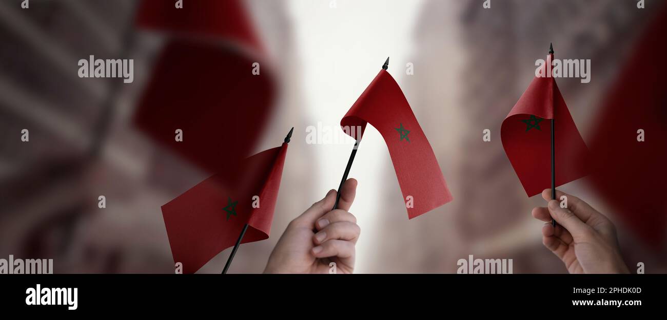 A group of people holding small flags of the Morocco in their hands ...