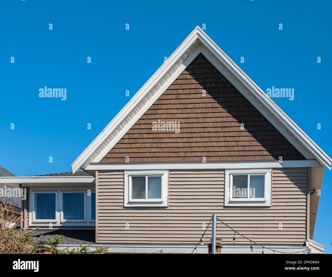 Top of a house with nice windows in the blue sky background. Beautiful ...