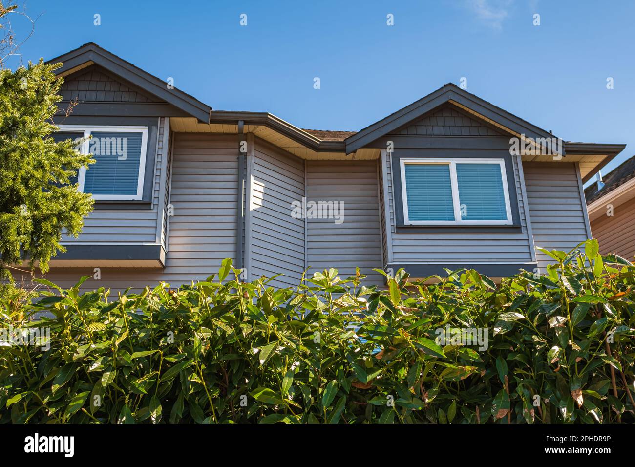 Top of a house with nice windows in the blue sky background. Beautiful ...