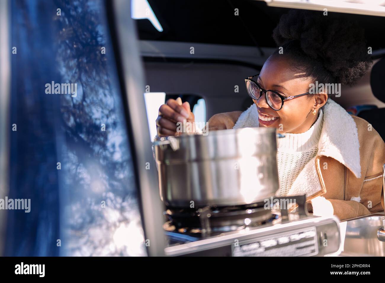 black woman cooking in camper van during road trip Stock Photo - Alamy