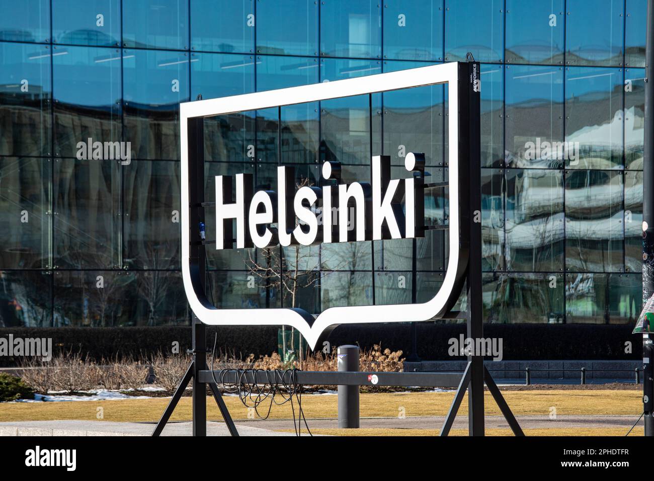 Helsinki logo light sign against a backdrop of Musiikkitalo windows in ...