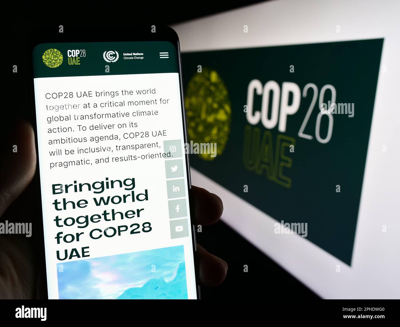 Person holding cellphone with web page of UN climate change conference COP28 (Dubai) on screen ...