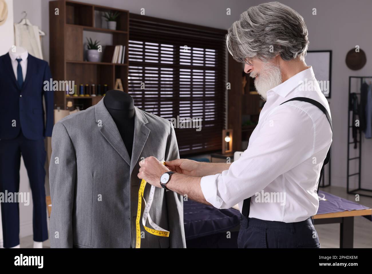 Professional tailor with measuring tape working in atelier Stock Photo ...