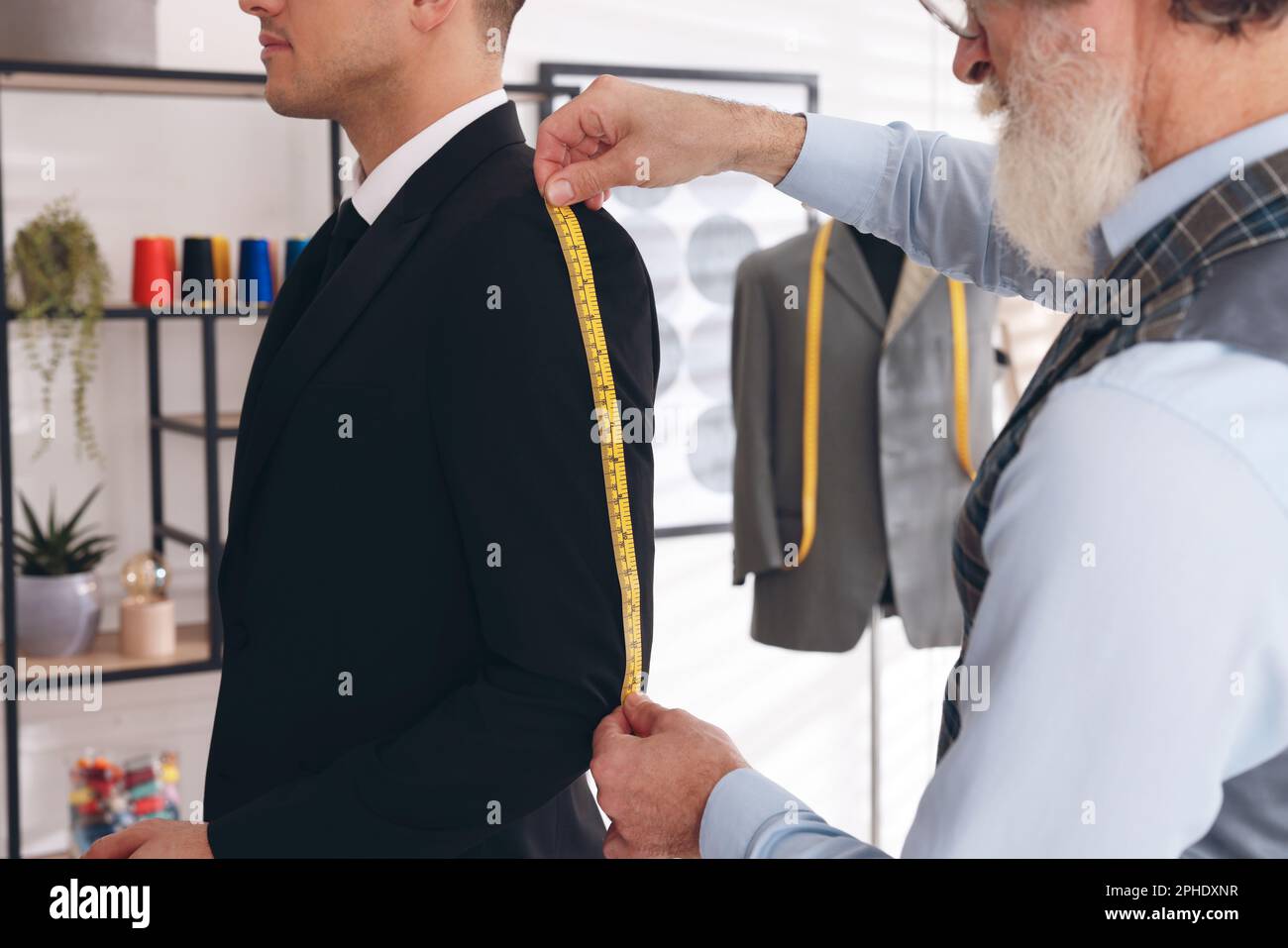 Tailor measuring jacket length hi-res stock photography and images - Alamy