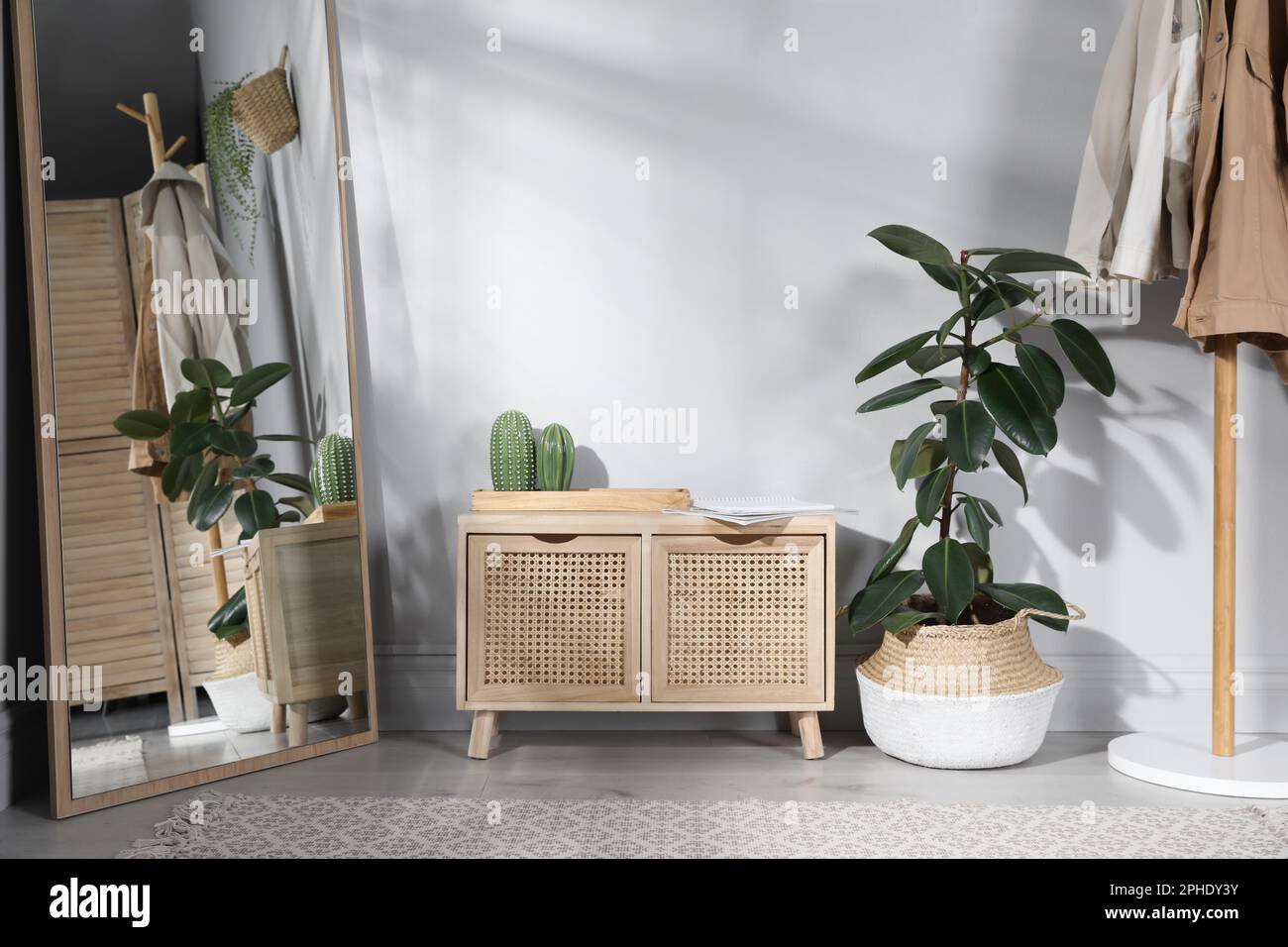 Stylish hallway room interior with wooden commode, coat rack and large ...