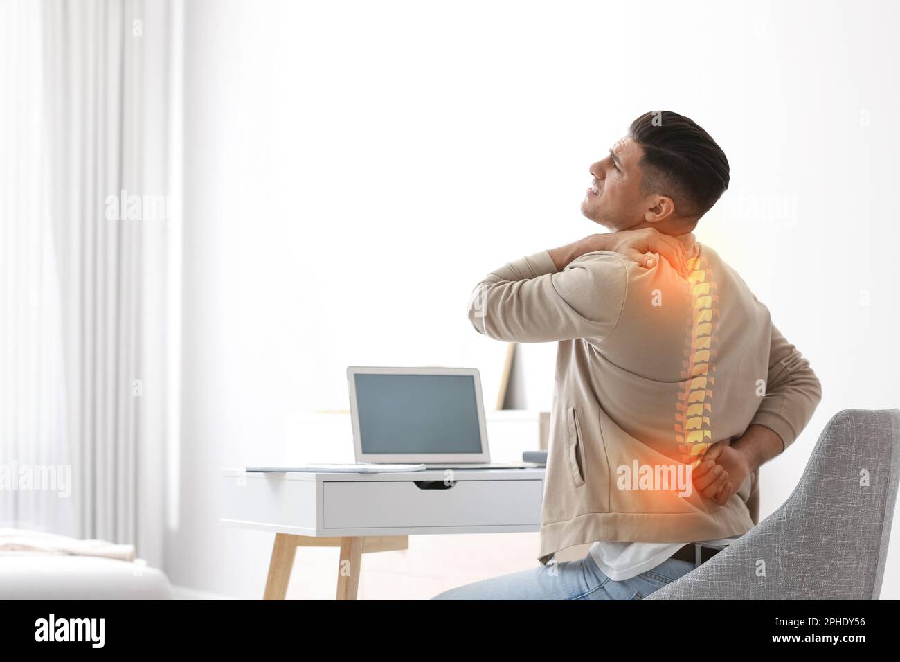 Man suffering from back pain at workplace. Bad posture problem Stock ...