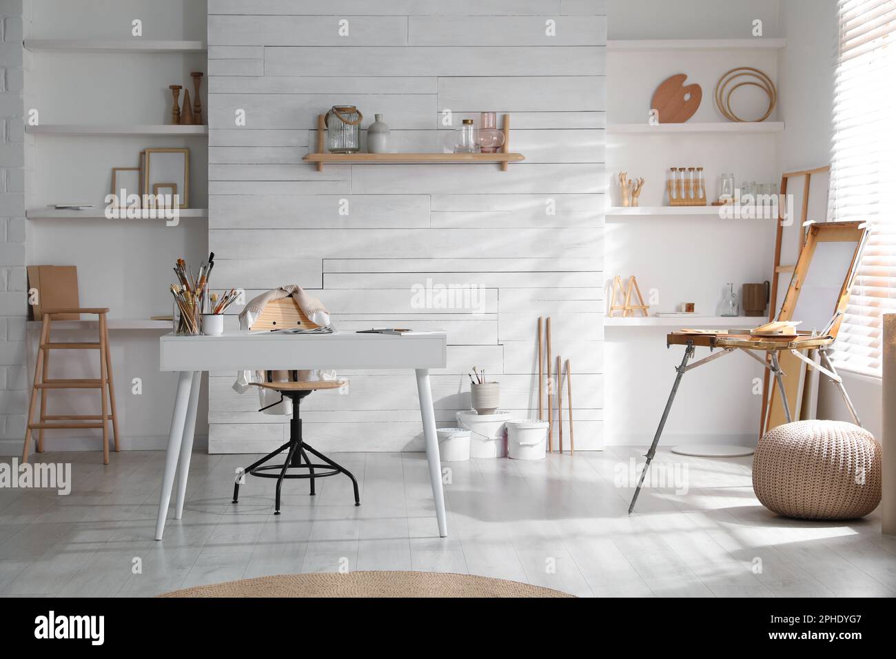 Modern studio interior with artist's workplace and wooden easel near ...