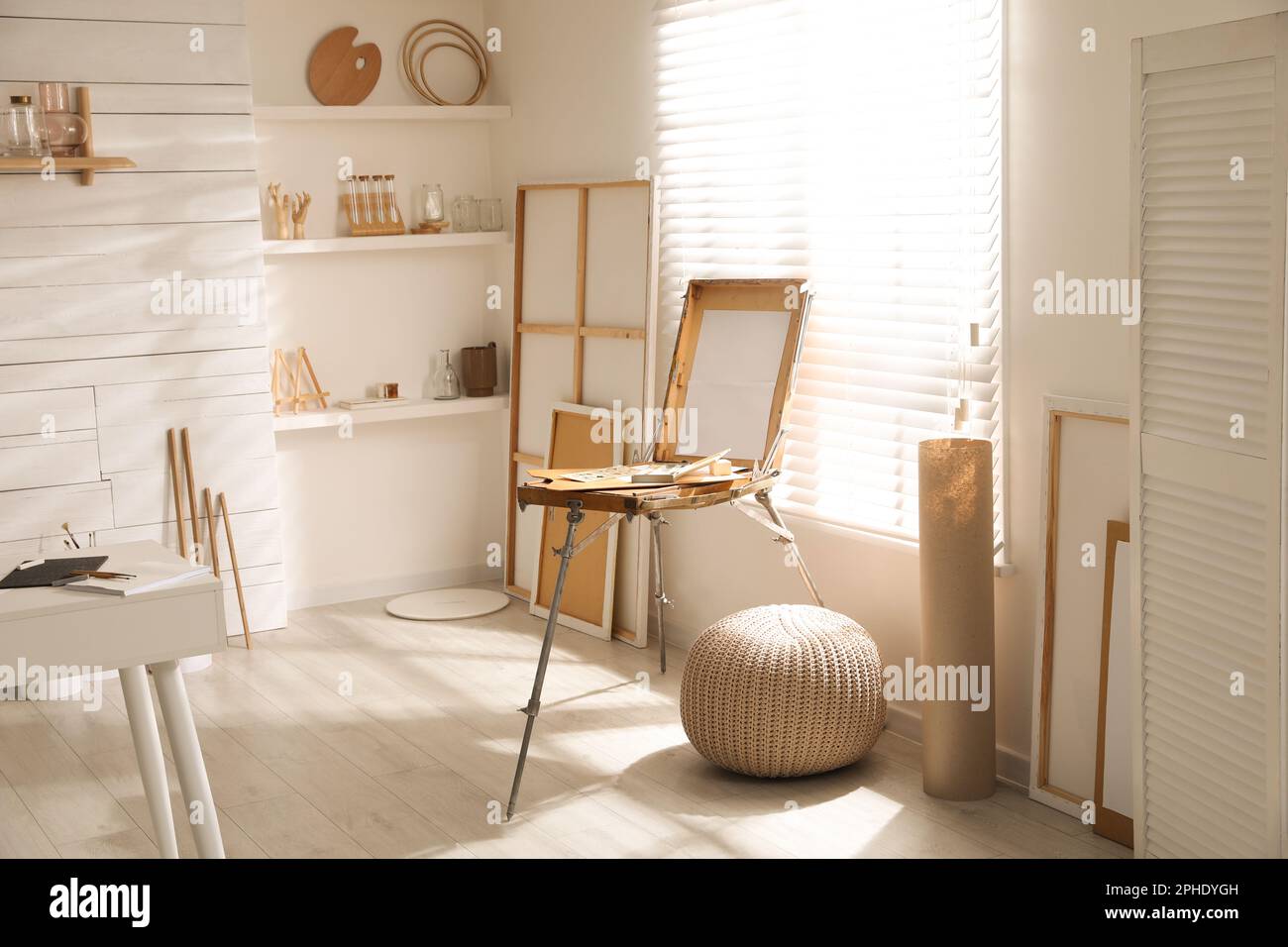 Modern studio interior with artist's workplace and wooden easel near ...