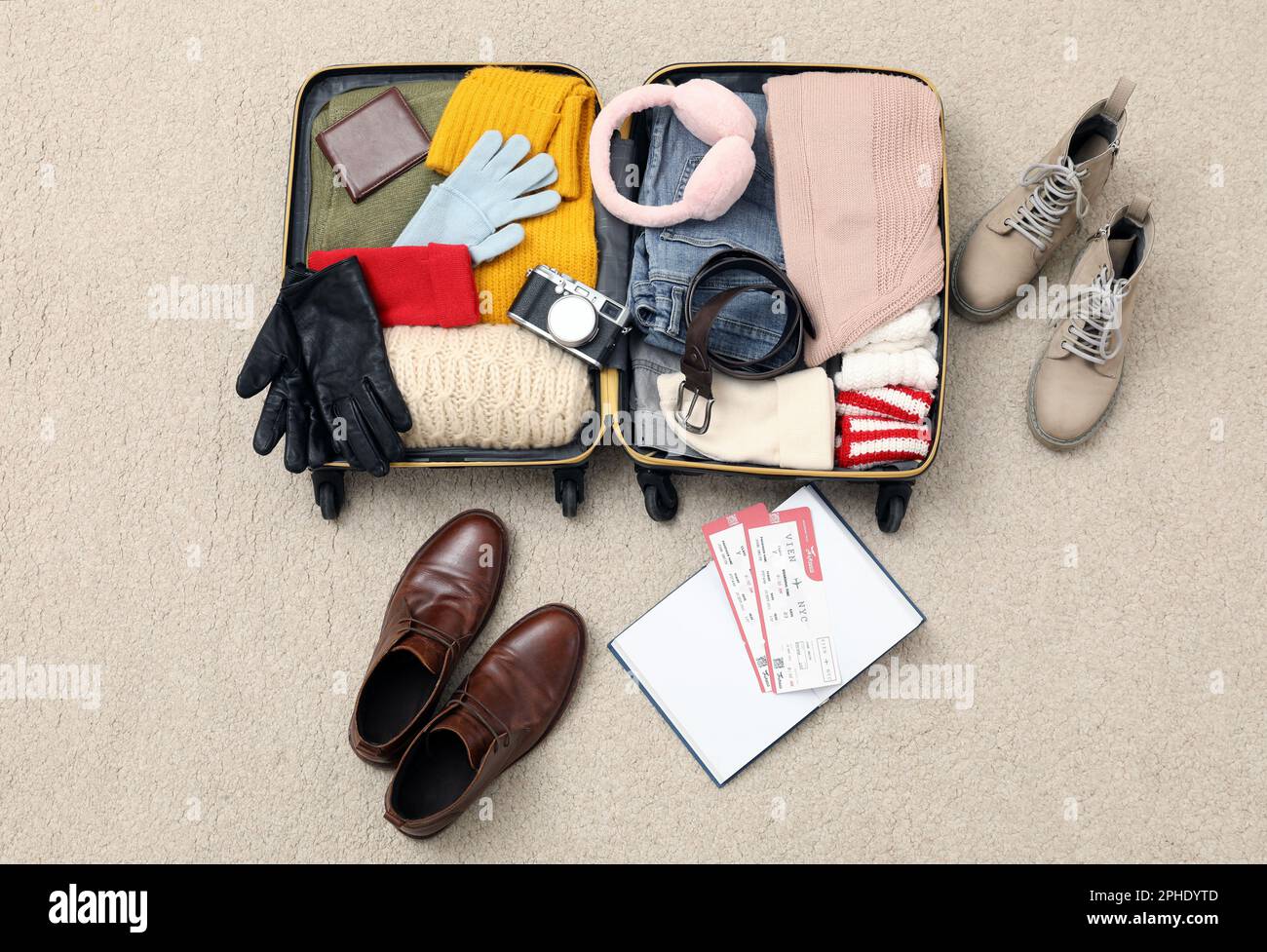 Open suitcase with warm clothes, accessories and shoes on floor, flat lay Stock Photo - Alamy