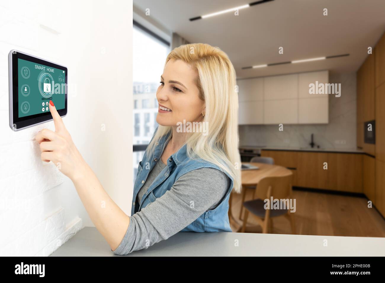 pretty blonde woman using smart home control panel Stock Photo - Alamy