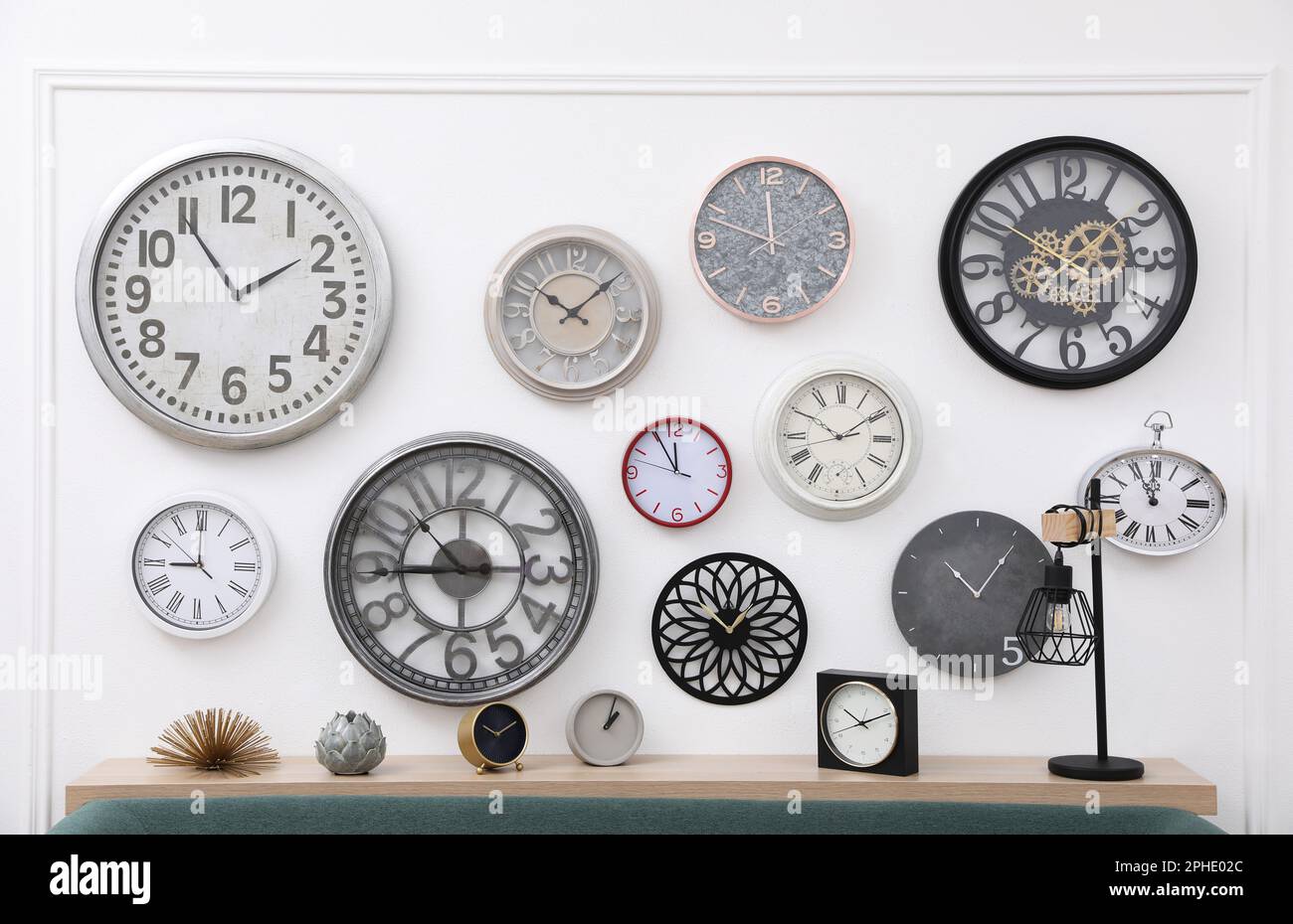Collection of different clocks on white wall in room Stock Photo - Alamy
