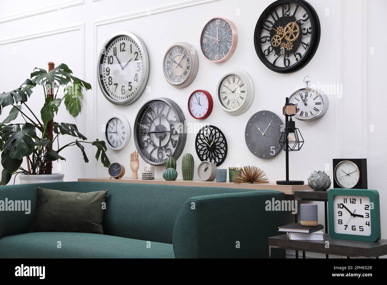 Collection of different clocks and comfortable sofa in stylish room ...