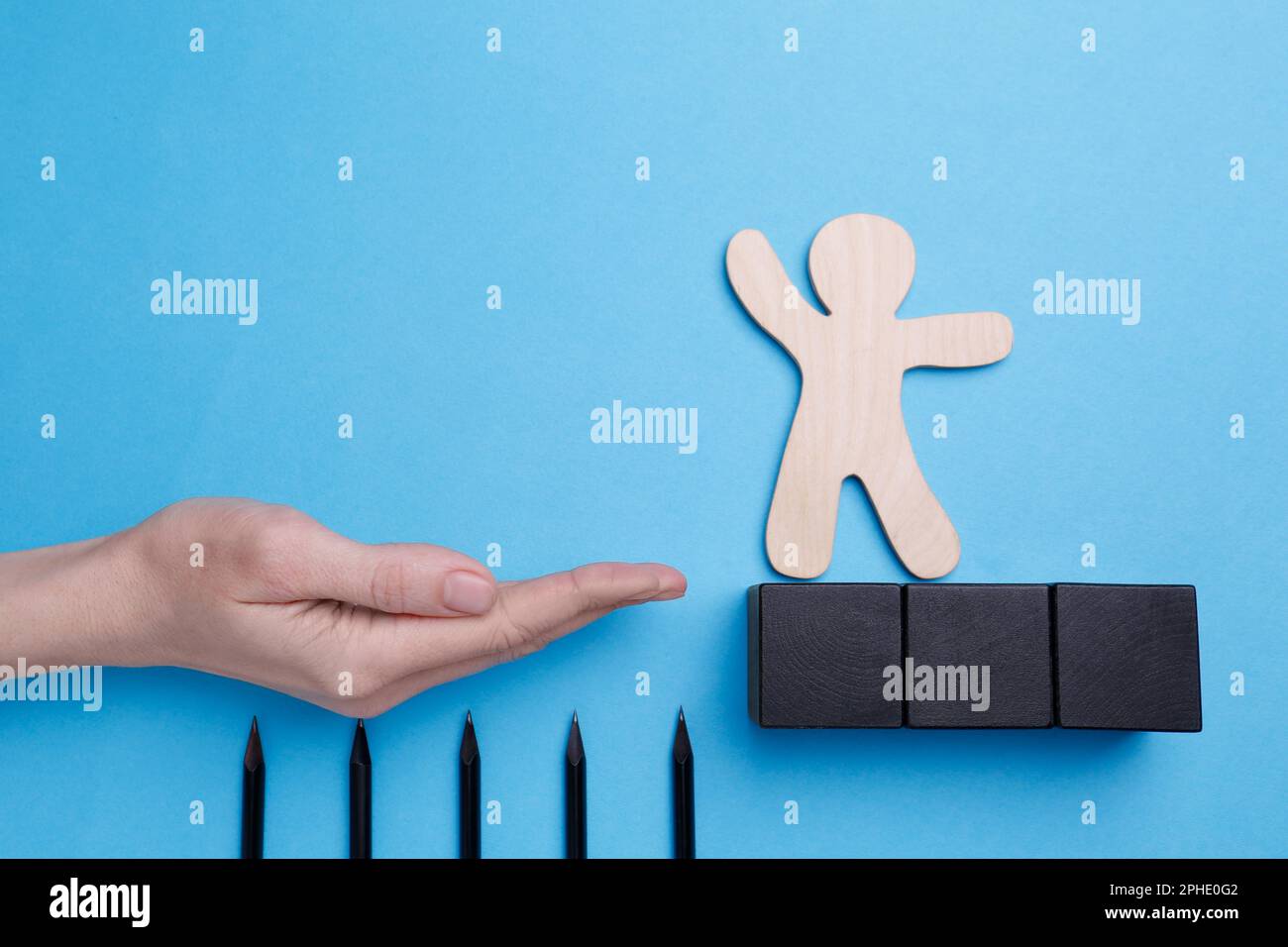 Woman holding hand to help human figure avoid trap with pencils as ...