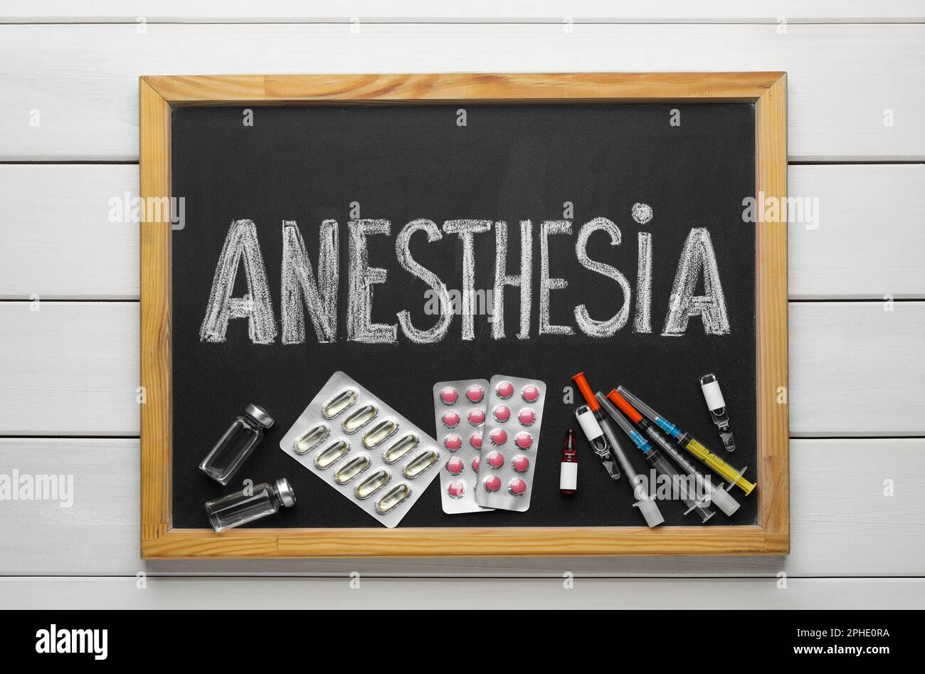 Blackboard with word Anesthesia, syringes and drugs on white wooden ...
