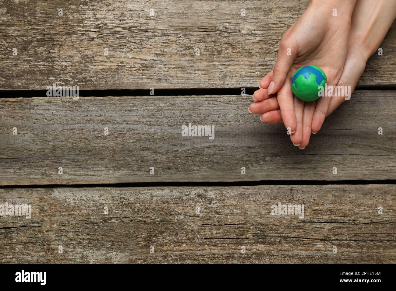 Happy Earth Day. Woman with plasticine planet at wooden table, top view ...