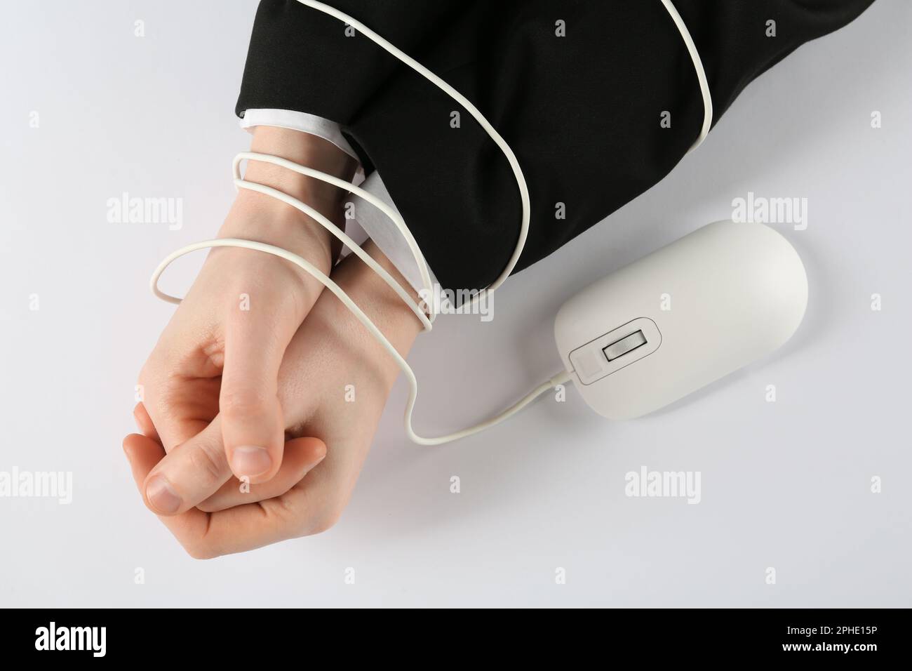 Man showing hands tied with mouse cable on white background, top view ...