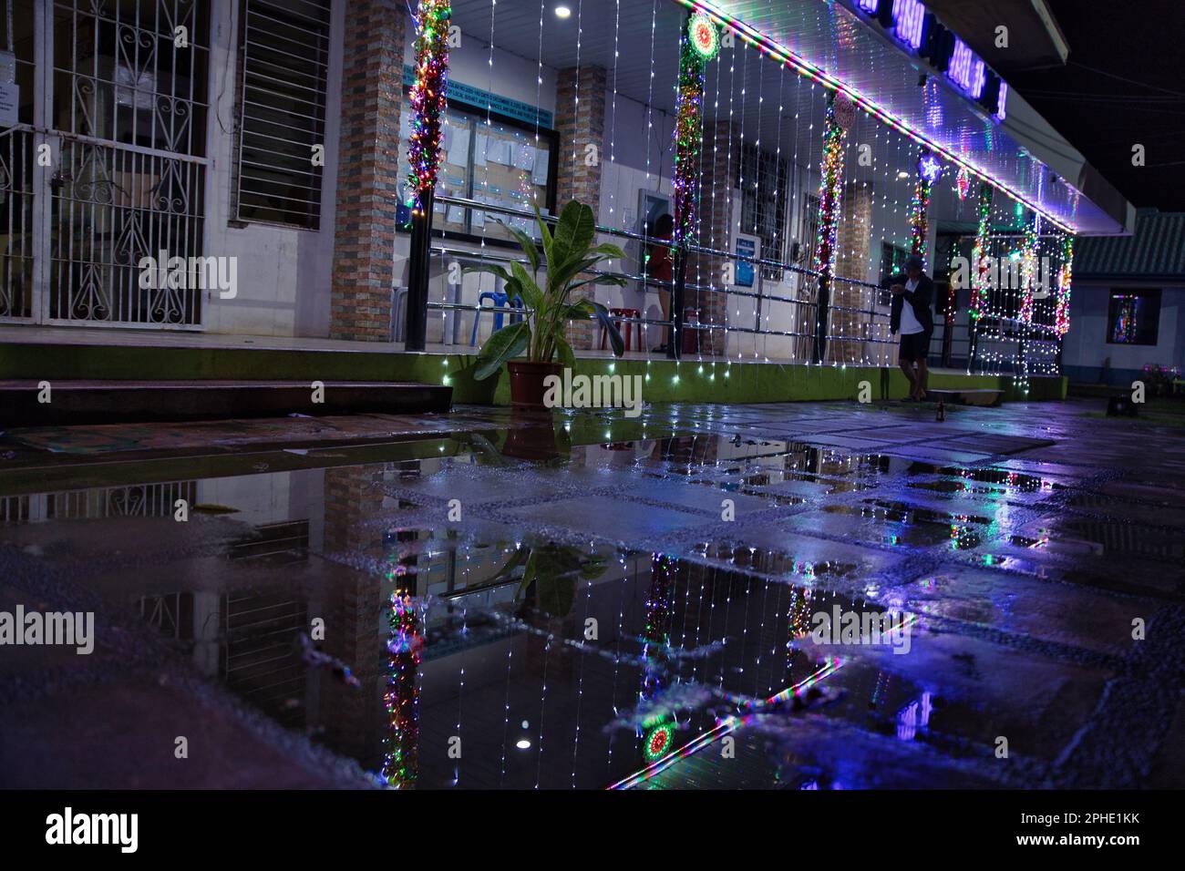 A Christmas decorated building with colorful lights at night reflecting ...