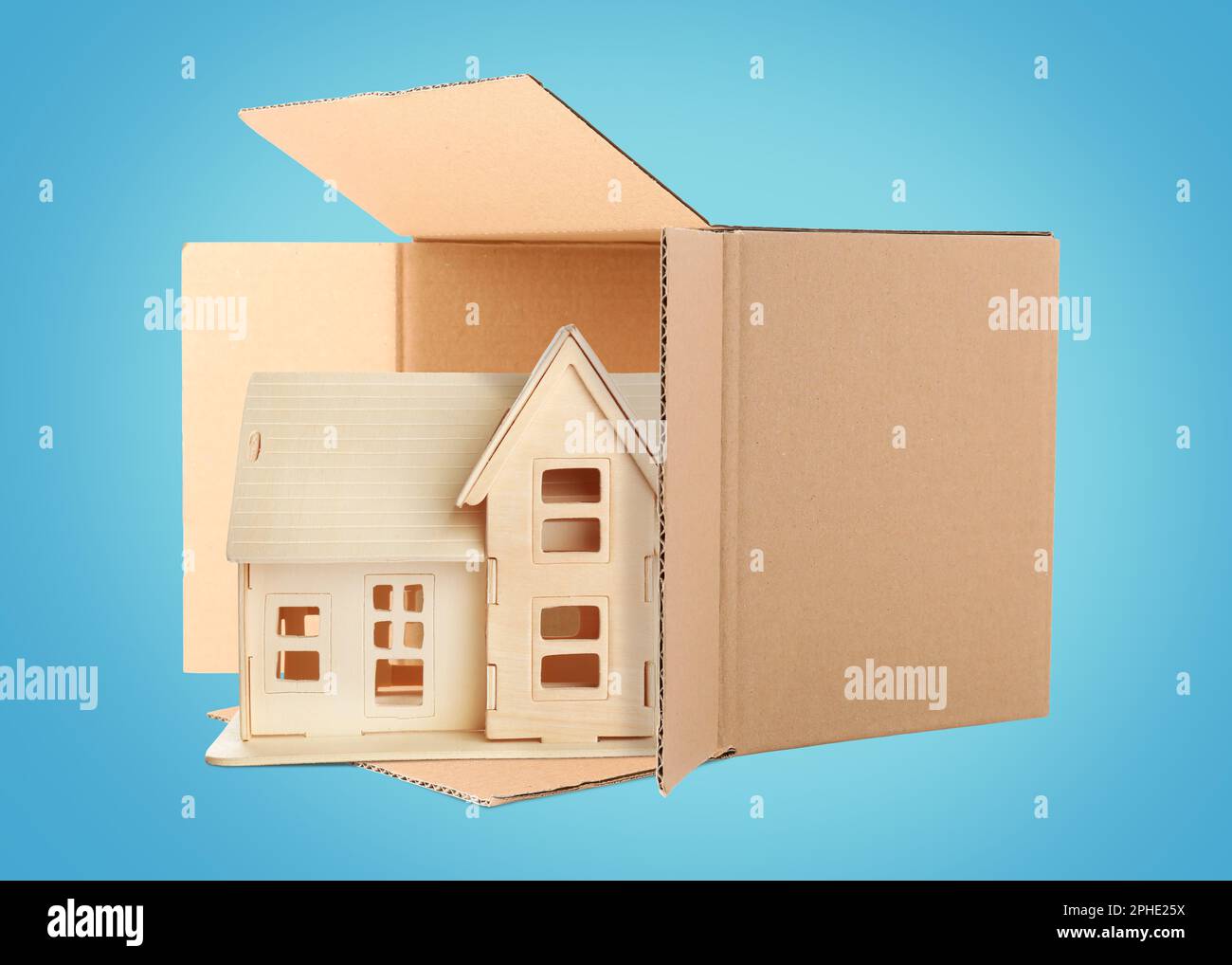Wooden model of house in cardboard box on turquoise background Stock ...