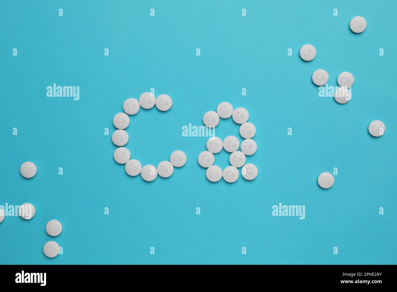 Flat lay composition with calcium supplement pills on light blue ...