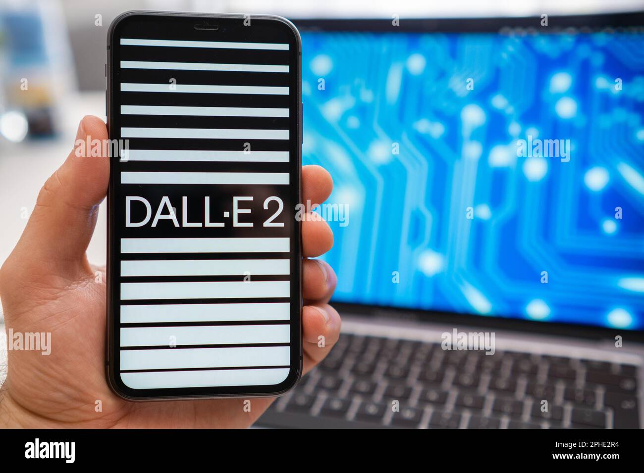 Dall E 2 logo of neural network on the screen of smartphone in mans hand and laptop with ...