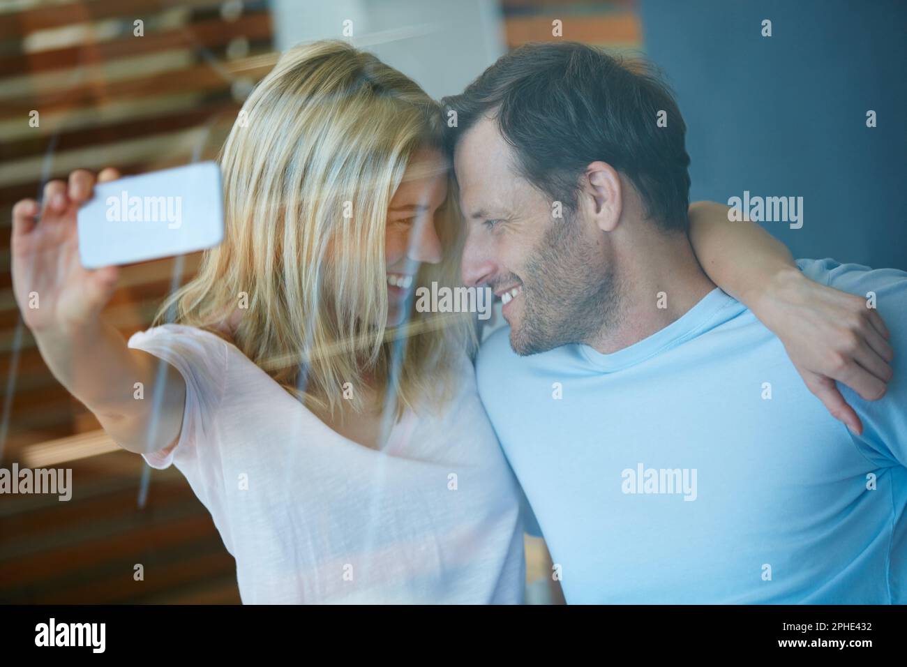 Our love is worth capturing. a young couple taking a selfie at home ...