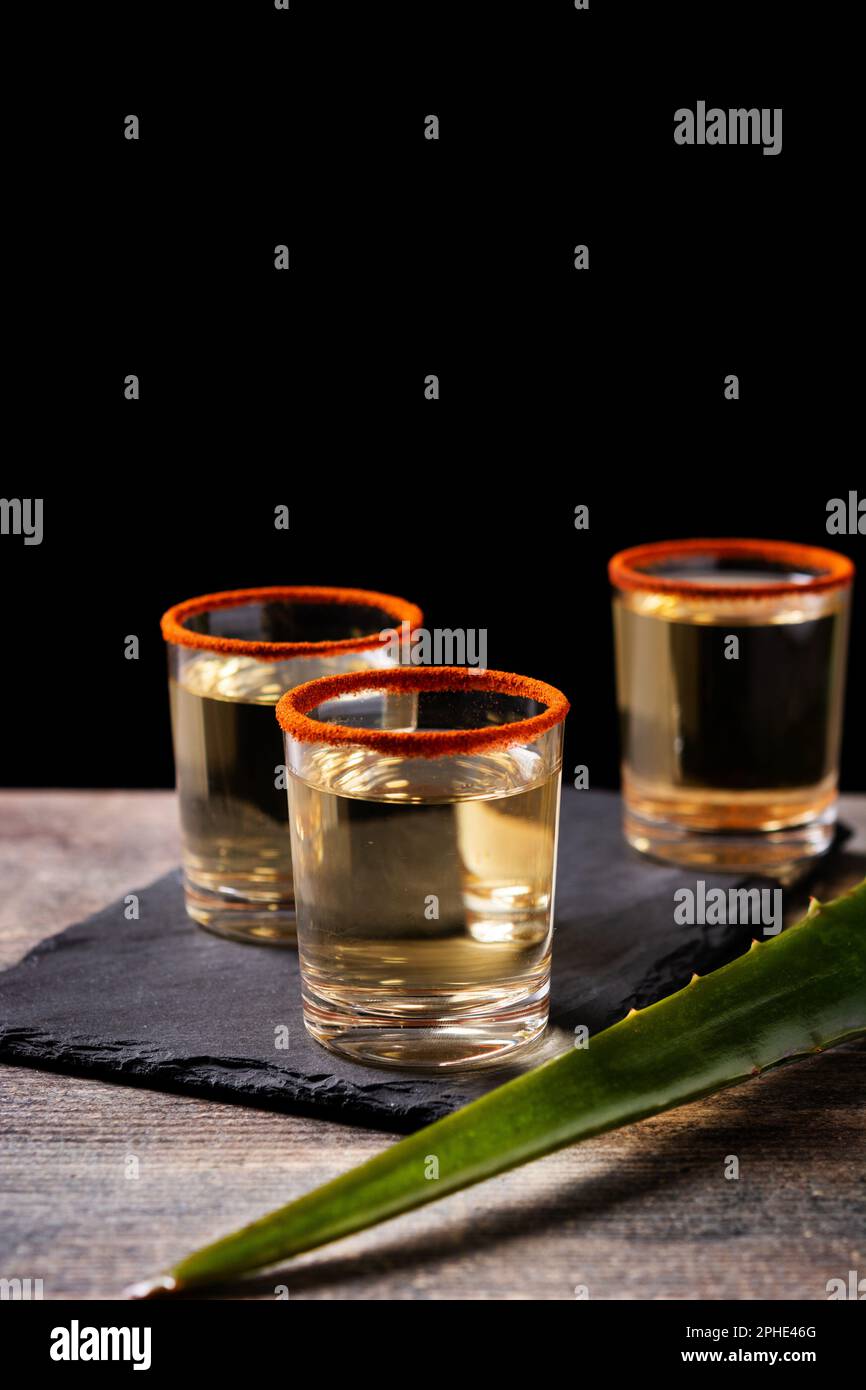 Mezcal Mexican drink with worm salt on wooden table Stock Photo - Alamy