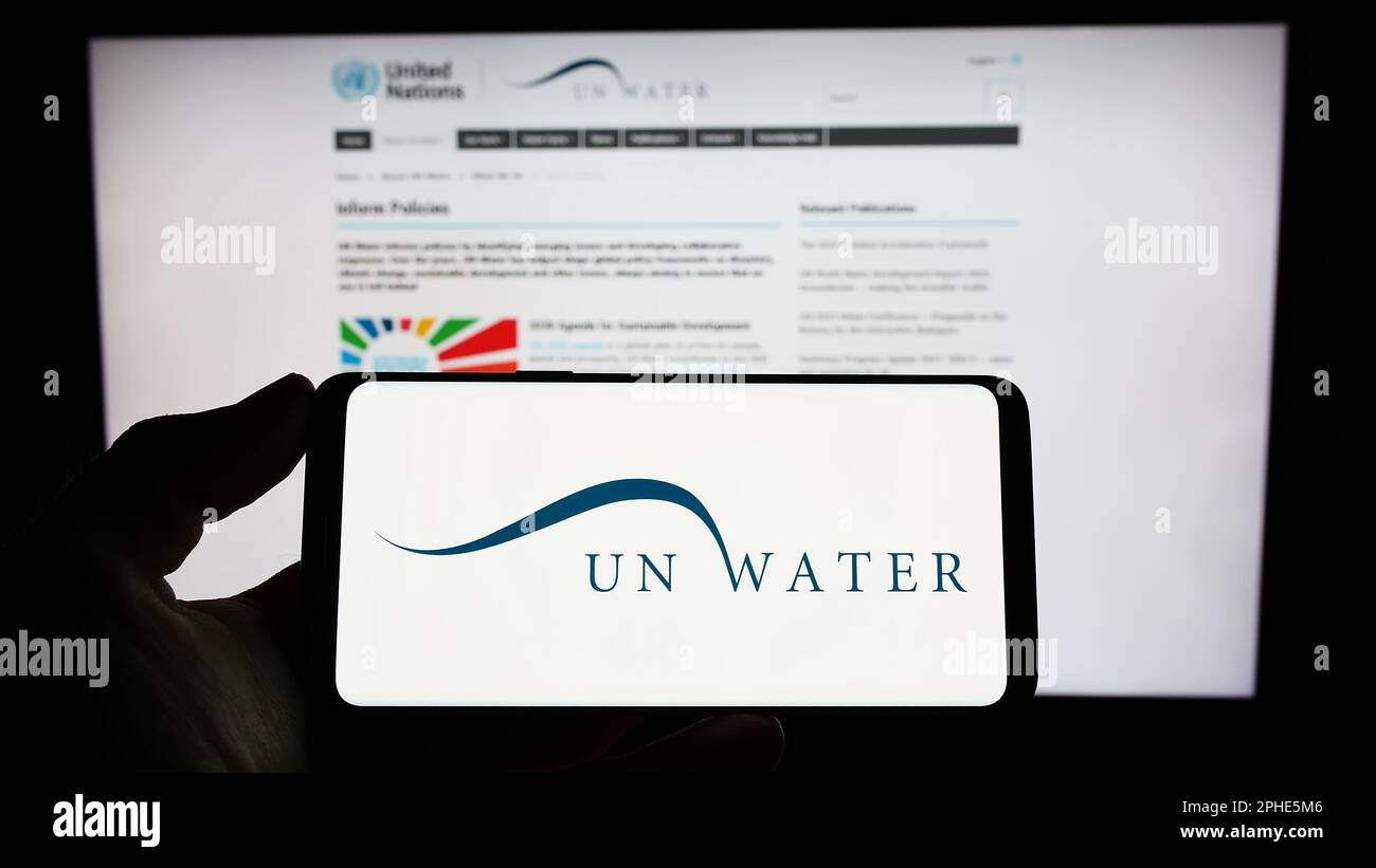 Person holding cellphone with logo of agency United Nations Water (UN ...