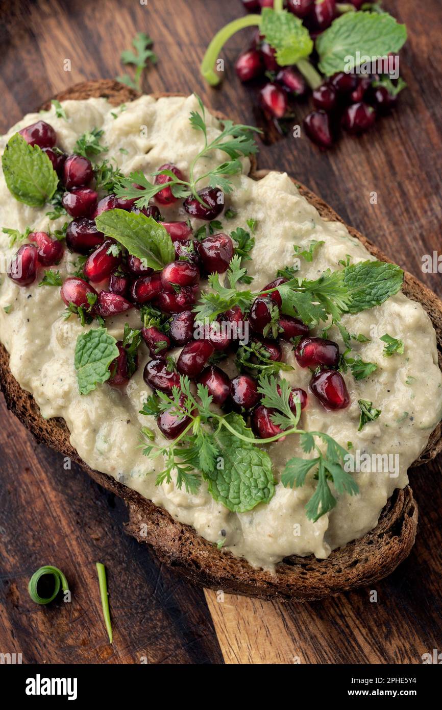 Baba ghanoush eggplant dip and pomegranate seeds on toast with wood ...