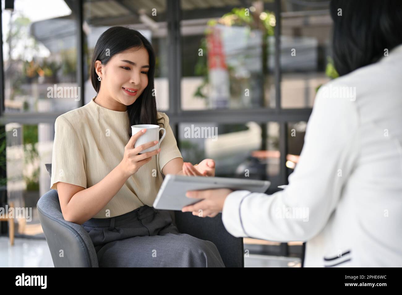 Attractive and gorgeous millennial Asian female CEO having an informal ...