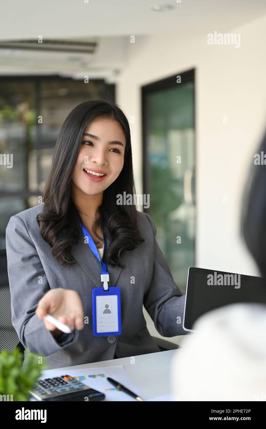 Portrait of a charming millennial Asian female banker or financial ...