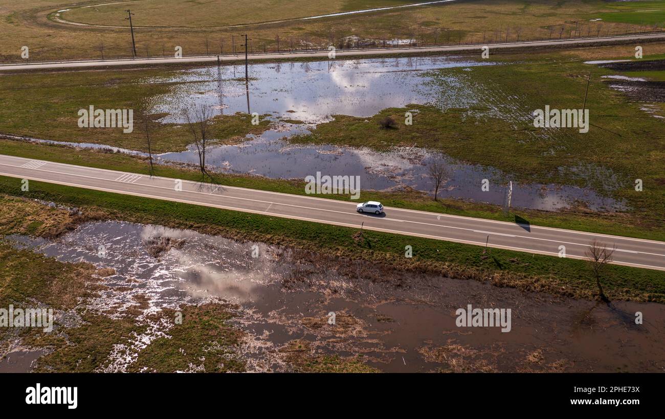 Aerial view of car driving along the highway through flooded ...