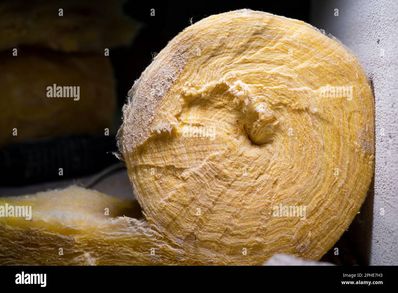 A roll of glass wool insulation close-up at a construction site with a ...