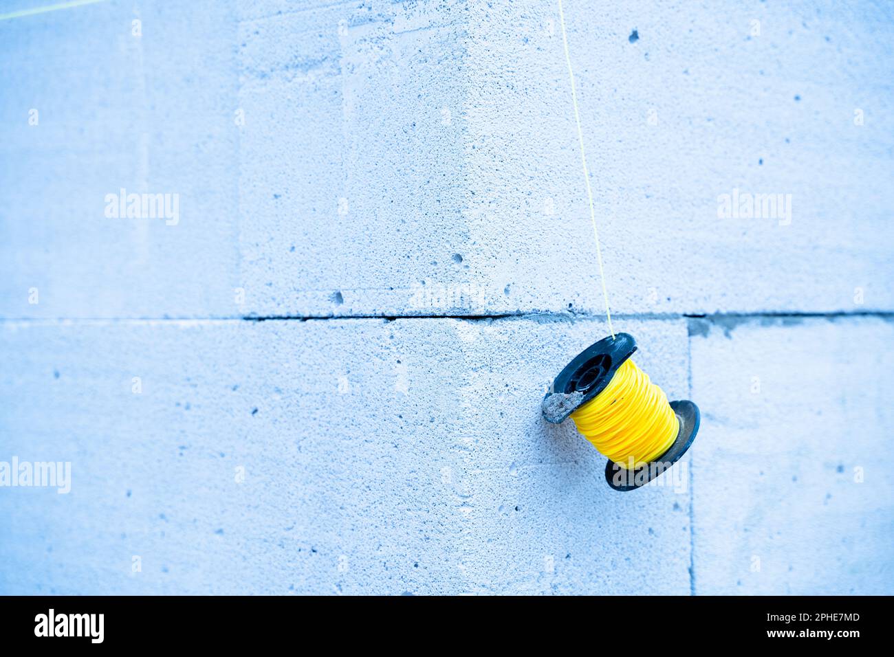 Yellow line of a bricklayer on a wall of aerated concrete bricks close ...