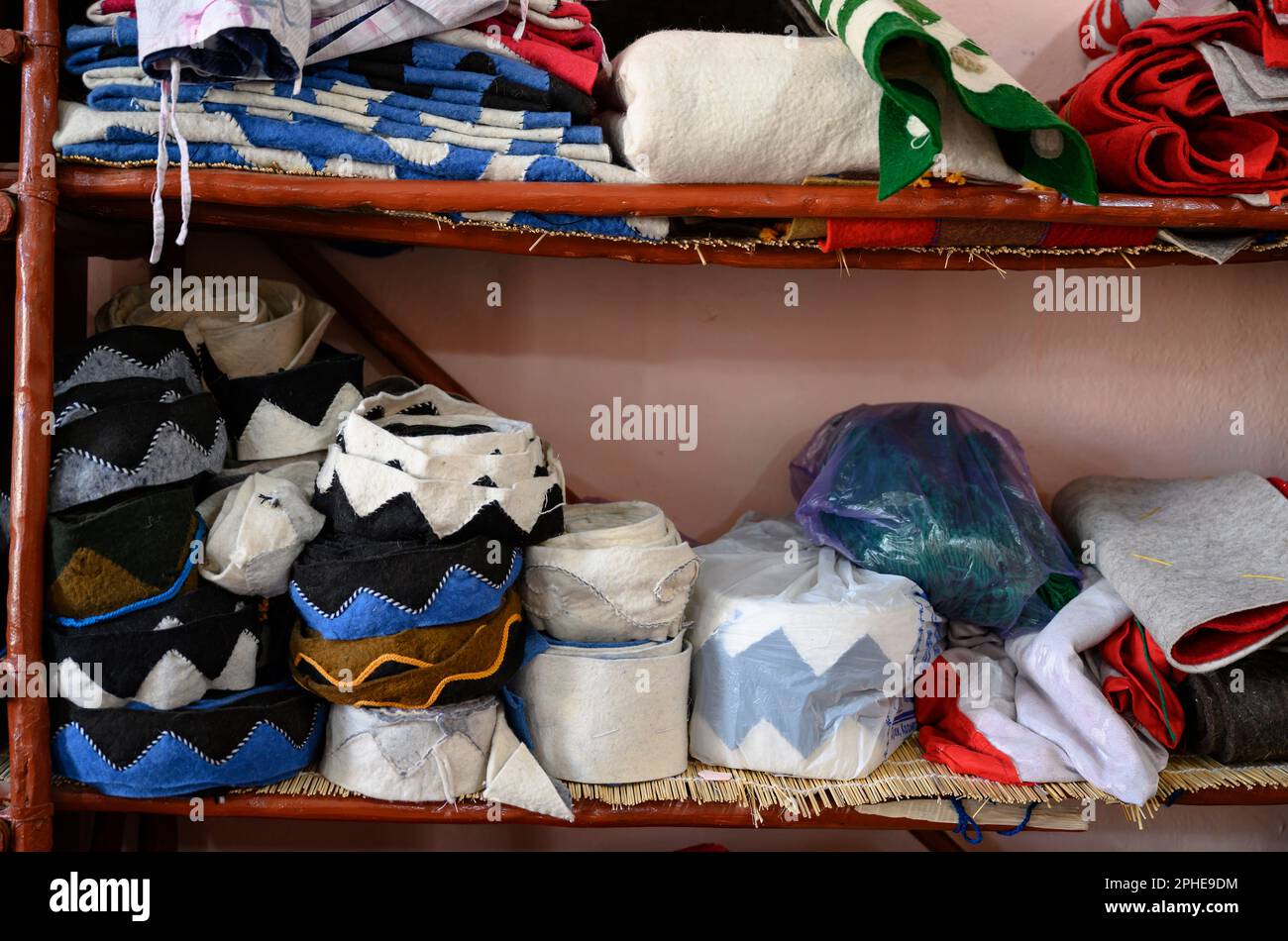 Shelves with bundles of colored felt with national Kyrgyz patterns in a ...