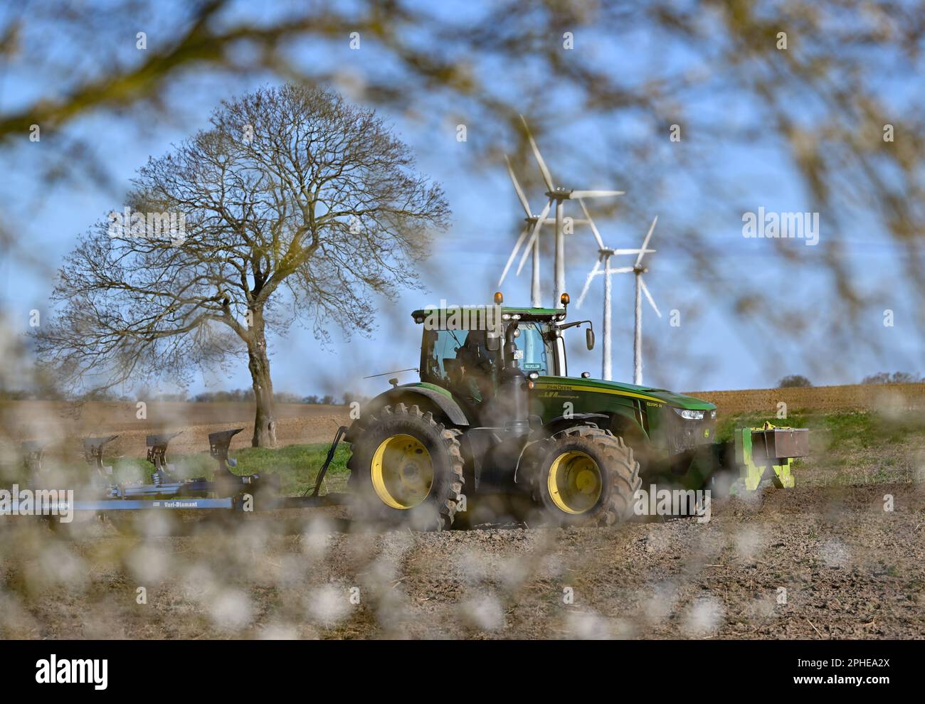 Lebus, Germany. 28th Mar, 2023. A farmer plows the soil with heavy ...