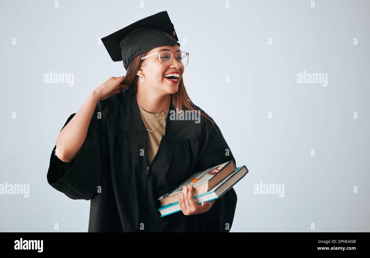 Graduation cap, books and happy woman isolated on studio background ...